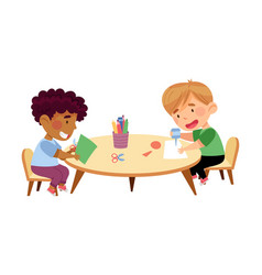 Little boys sitting at table paper crafting Vector Image